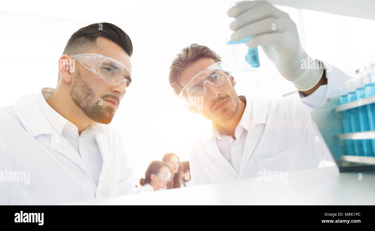 closeup. scientist and assistant studying the solution in the gl Stock ...