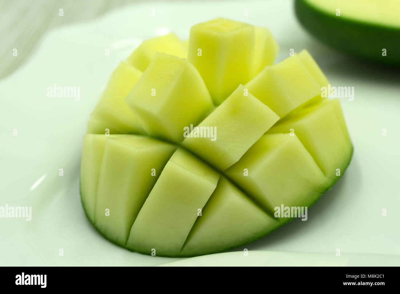 Fresh ripe mango Mangifera indica with a section cut in squares on a ...
