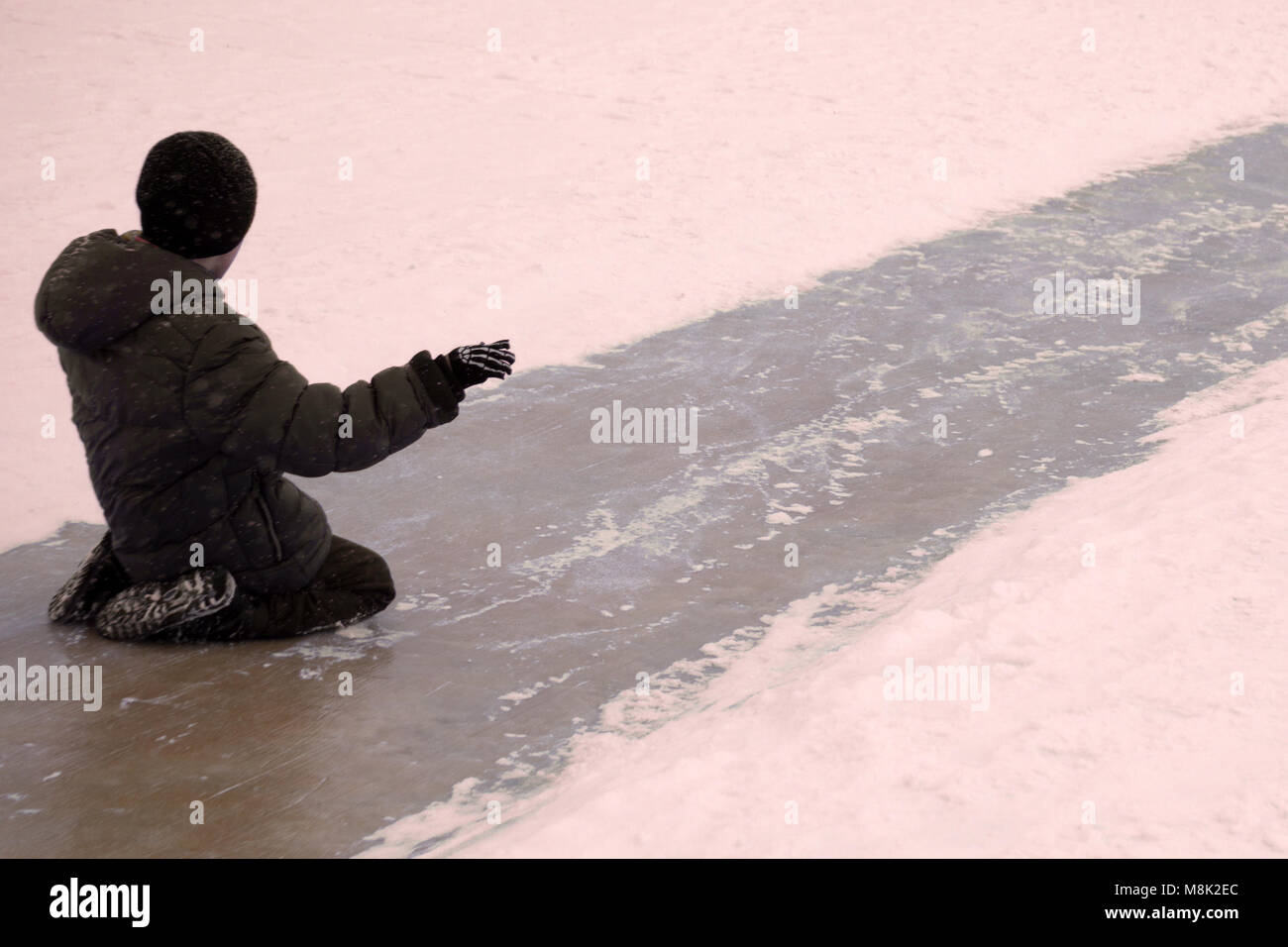 children having fun riding ice slide in winter Stock Photo - Alamy