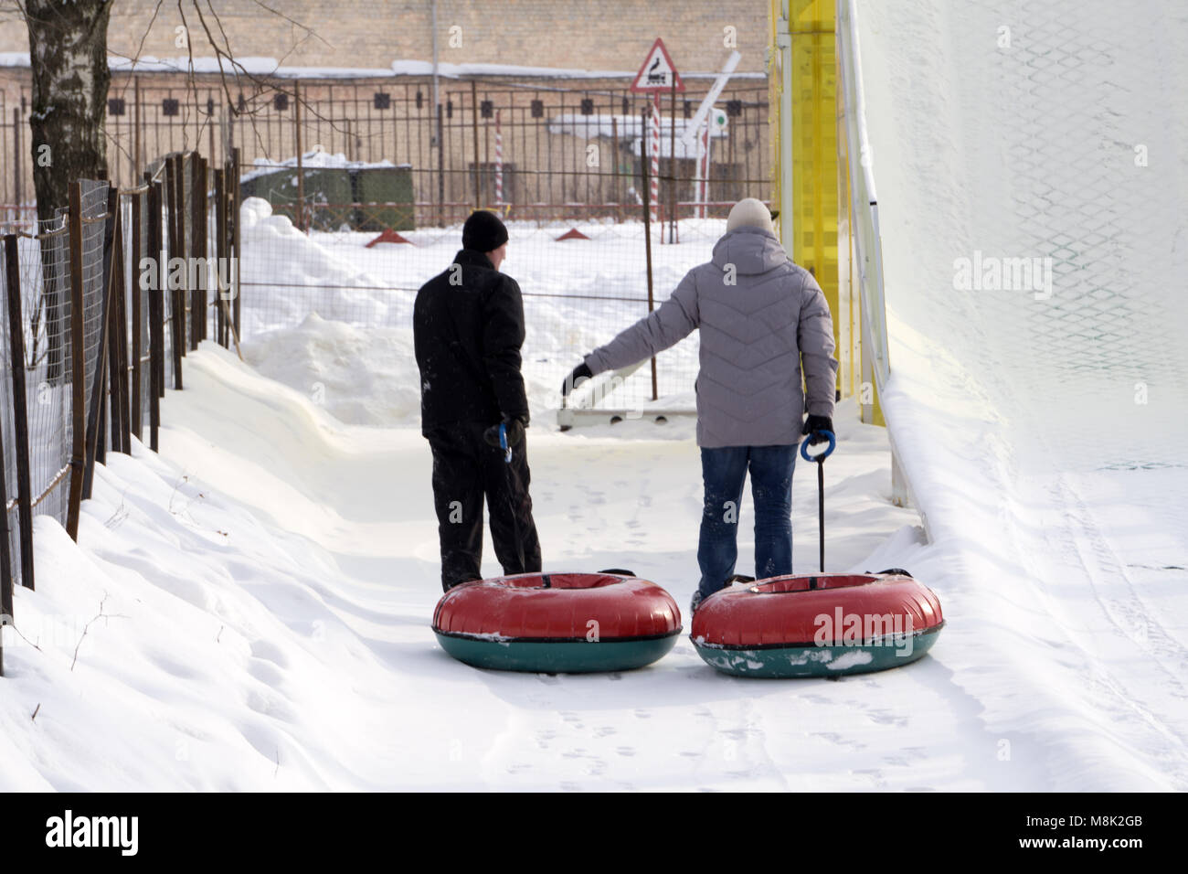 The guy and the girl are rushing from the slide on the tubing Stock ...