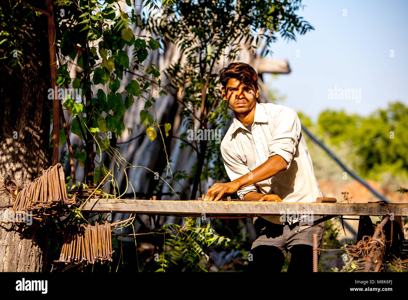 A handsome young man is working outdoor in Indian village Nipal ...