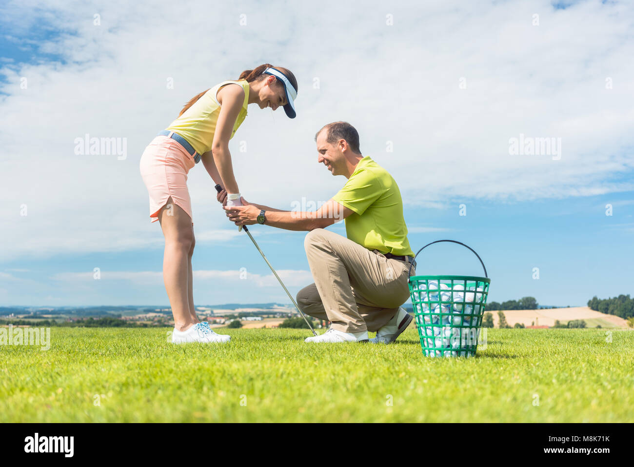 Young woman exercising the golf swing helped by her instructor Stock ...