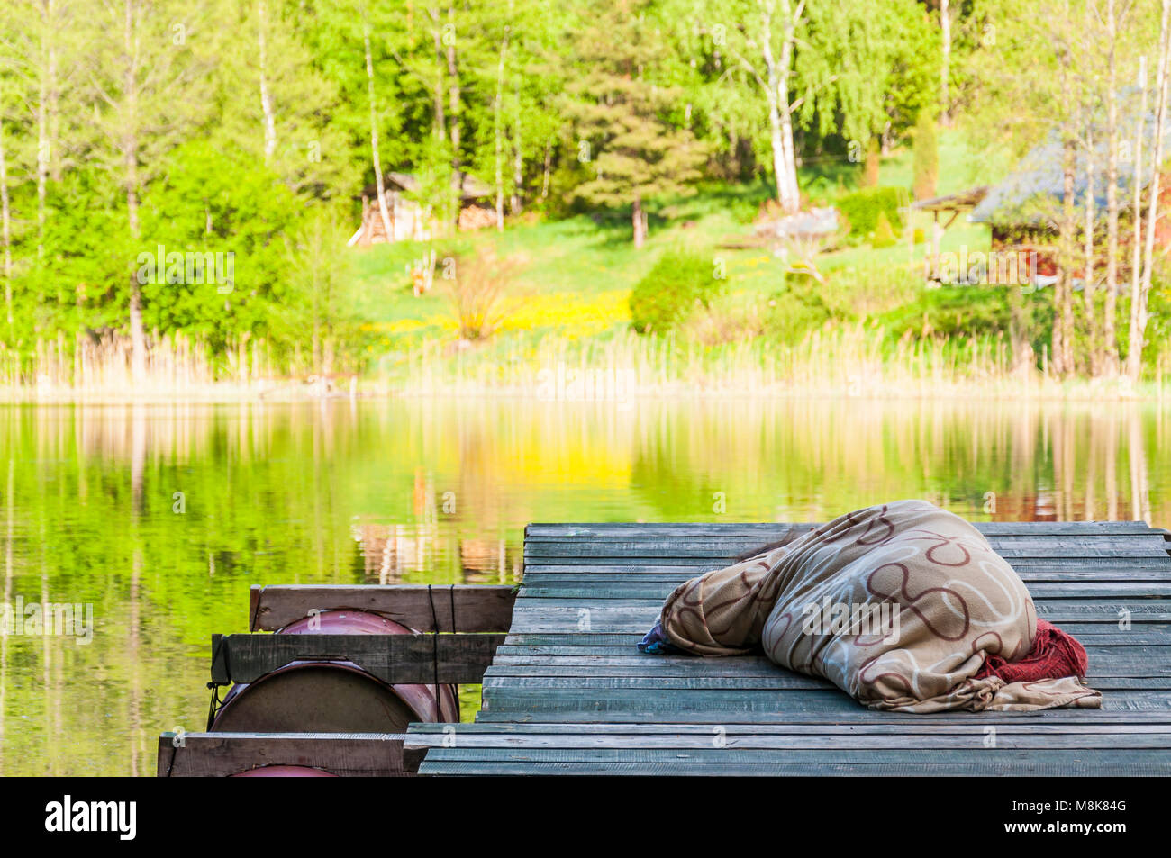 Amazing lake in the middle of emerald forest. Adult is sleeping on ...