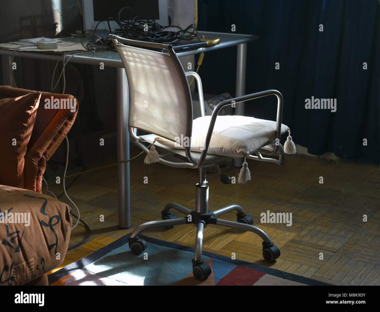 A chair in focus and a modern living room with messy table in the ...