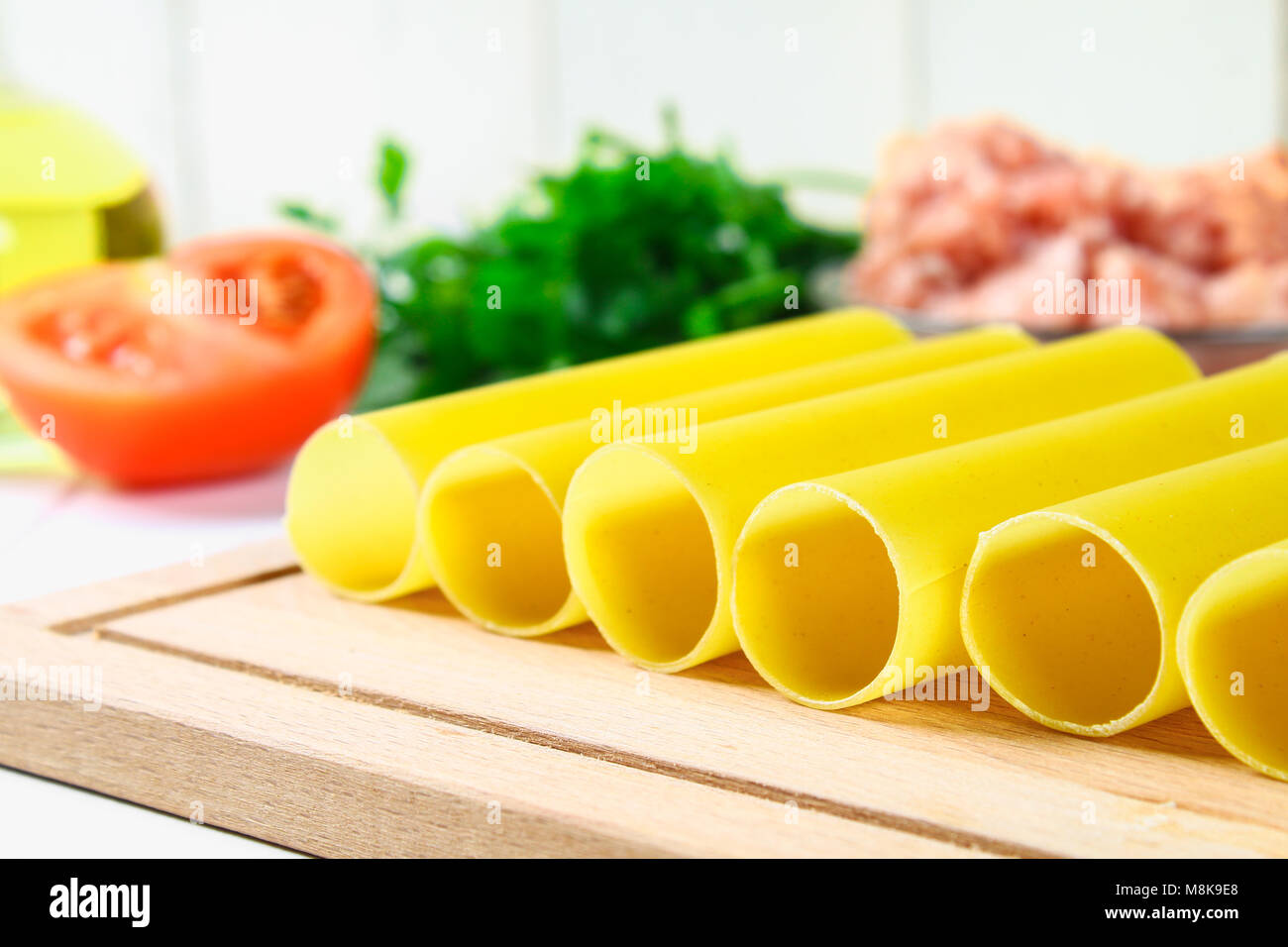 Italian pasta cannelloni. Raw tube for stuffing stuffing surrounded by ...