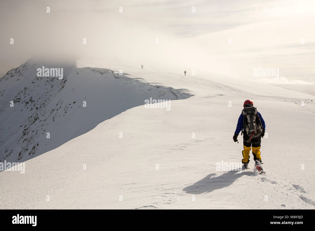 Mountaineers approaching the summit of Helvellyn in full winter ...