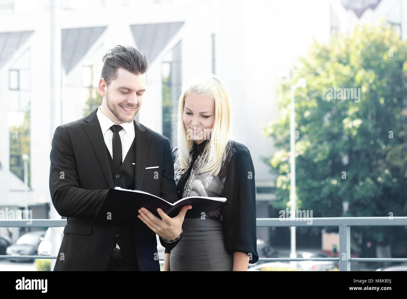 couple of employees reading documents standing near the office Stock ...