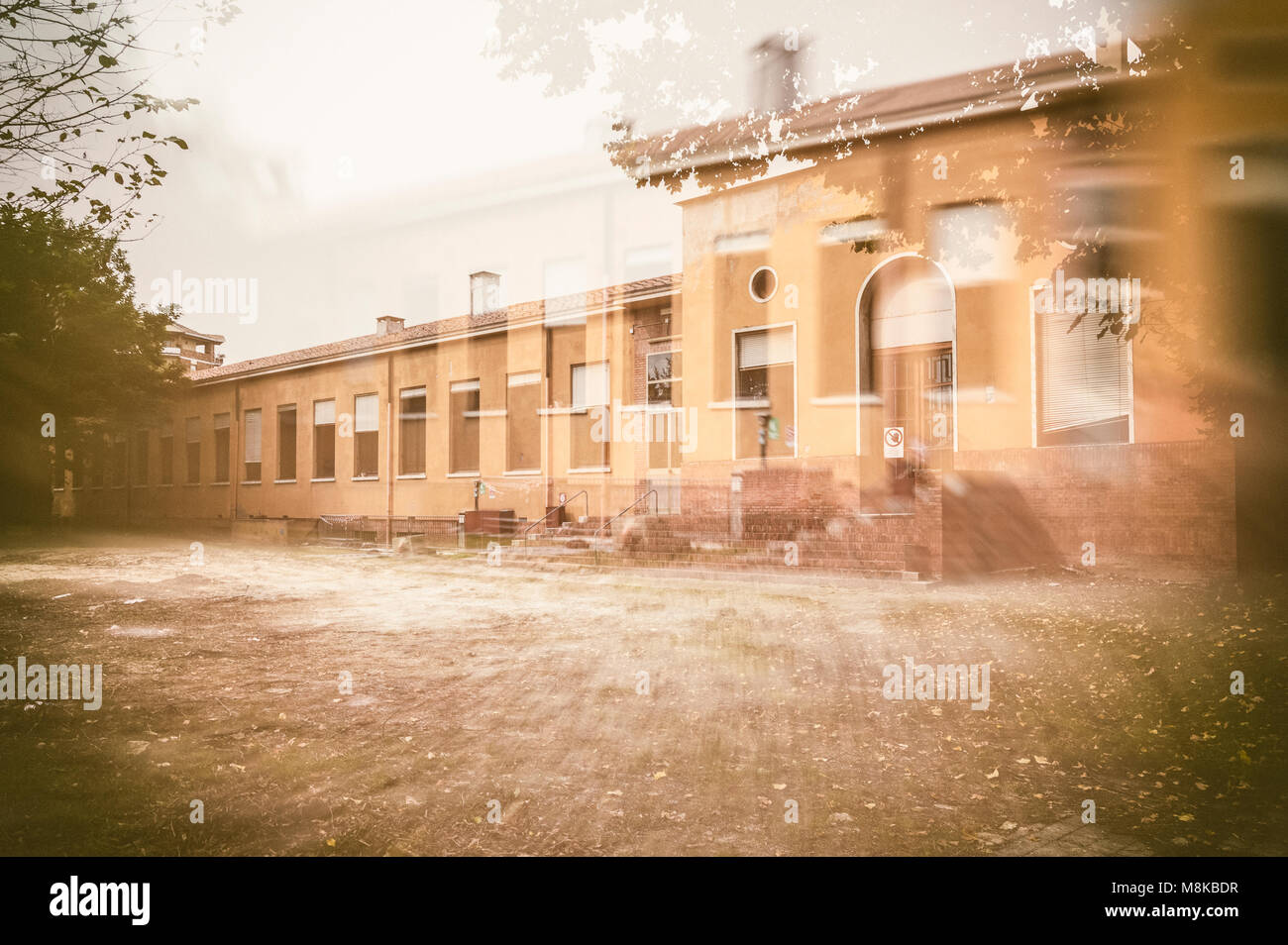 External facade of old and abandoned devastated school in double ...