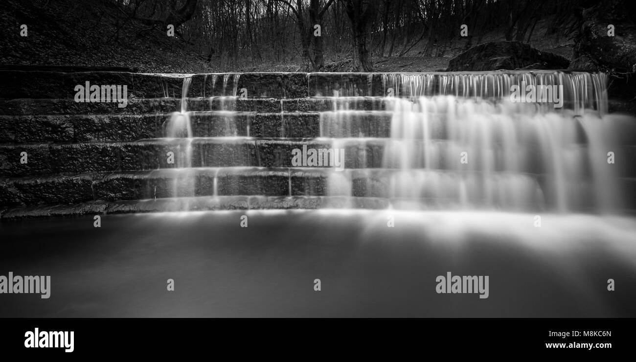 Stream flows down weir from Clough House Mill Pond Stock Photo - Alamy