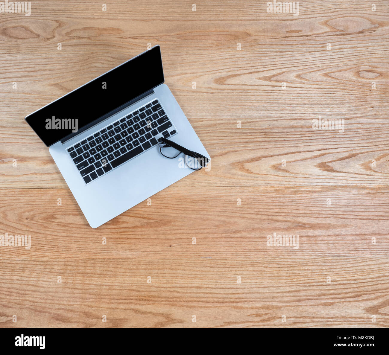Clean oak wooden desktop with laptop computer and reading glasses Stock ...