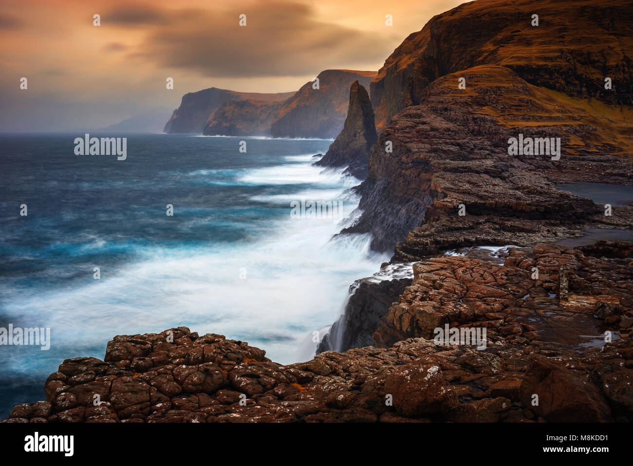 Bosdalafossur waterfall on Vagar island coastline in sunset, Faroe ...