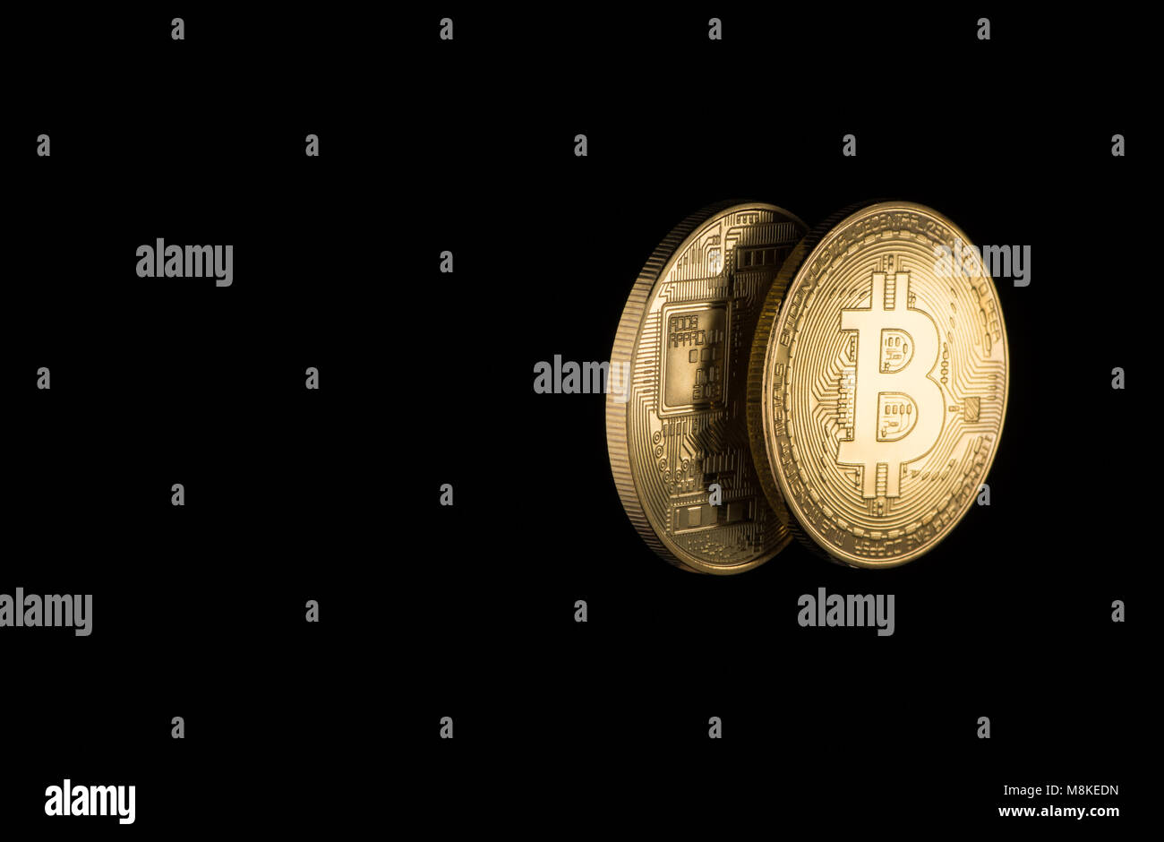 two Golden bitcoins on black background with copy space. electronic ...