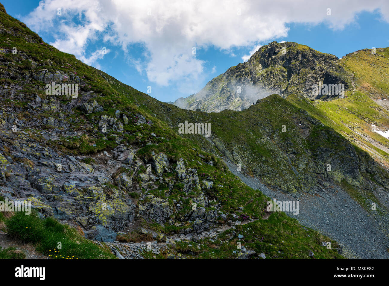 Peaks of mountain ridge among the clouds. Mighty formations with rocky ...