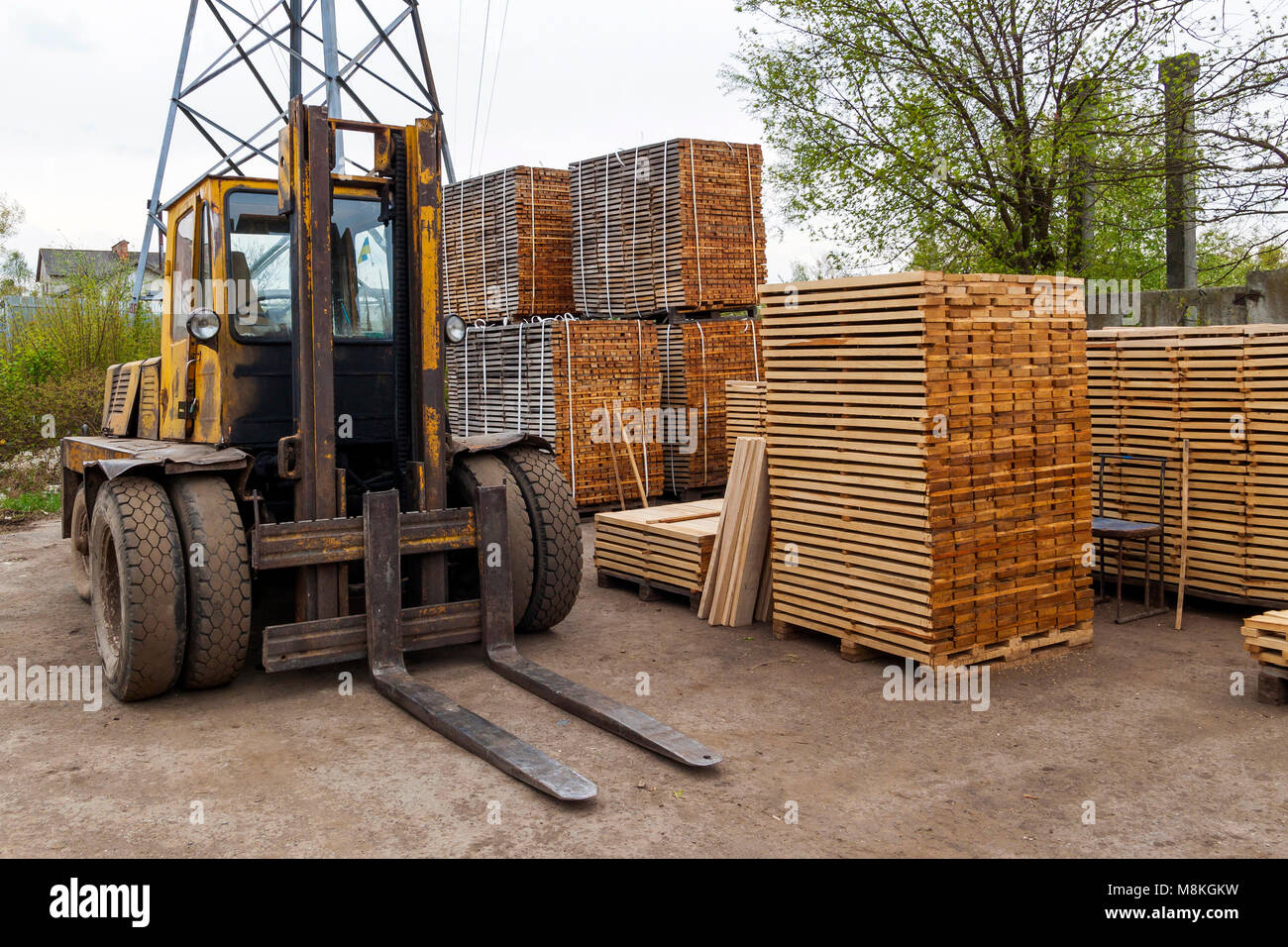 Large lift truck and stacks of new wooden boards and studs at the ...