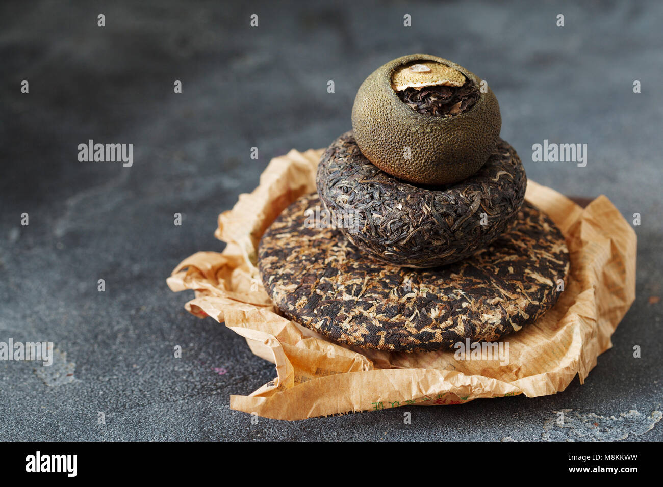 Asian pressed pu-erh tea and shu pu'er in tangerine on dark slate ...