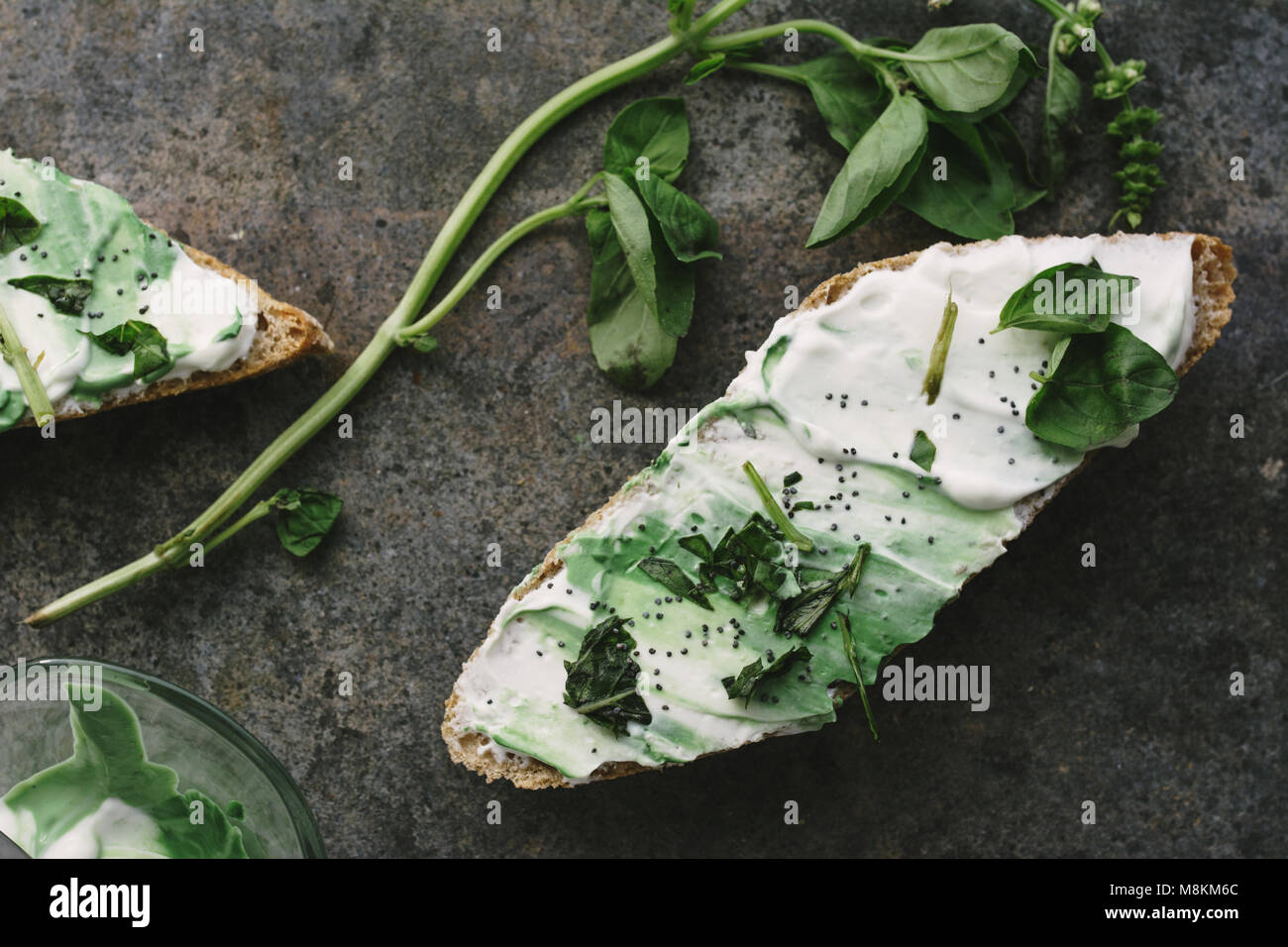 toast spread with cream cheese and basil, on grunge background Stock ...