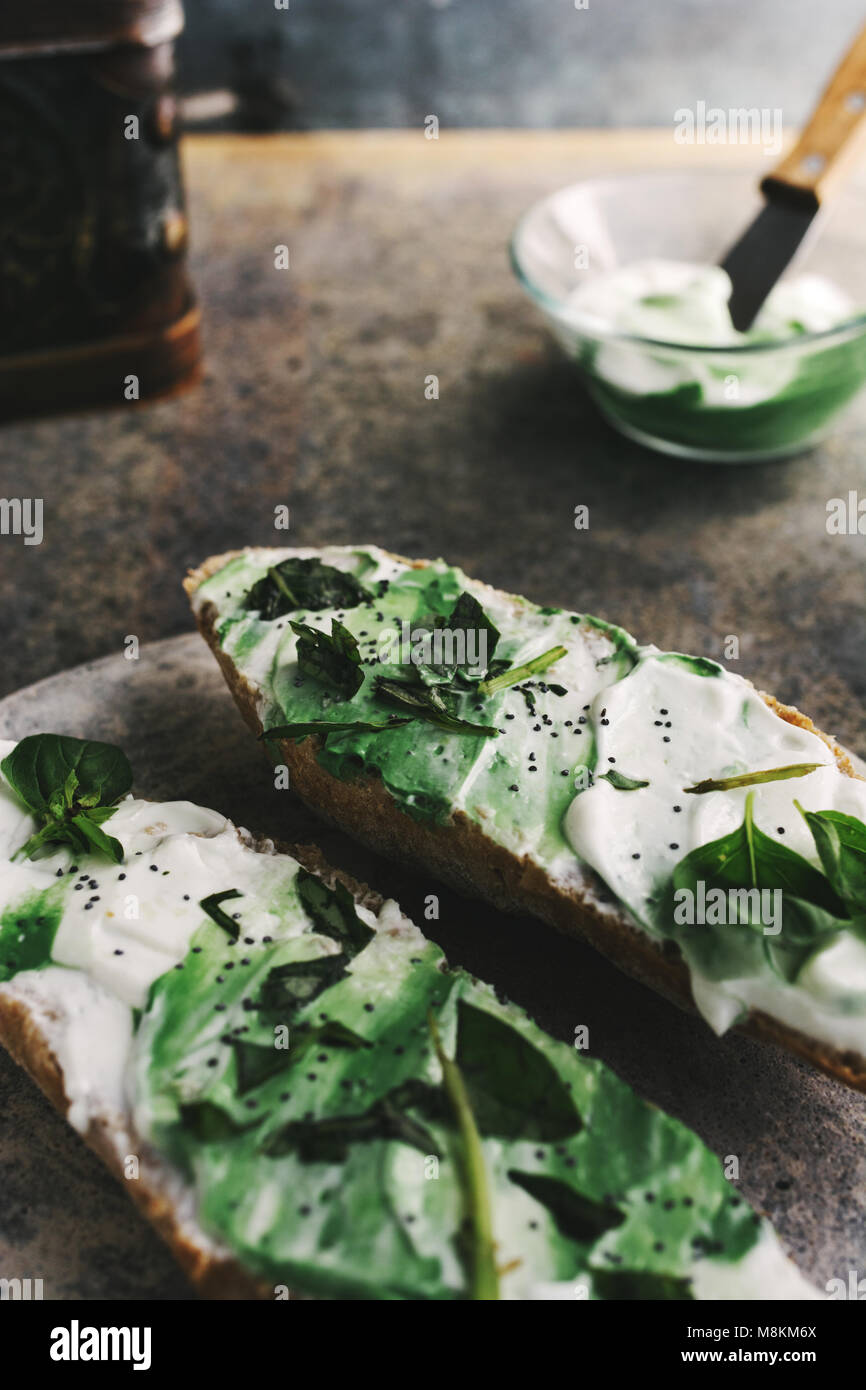 toast spread with cream cheese and basil, on grunge background Stock ...
