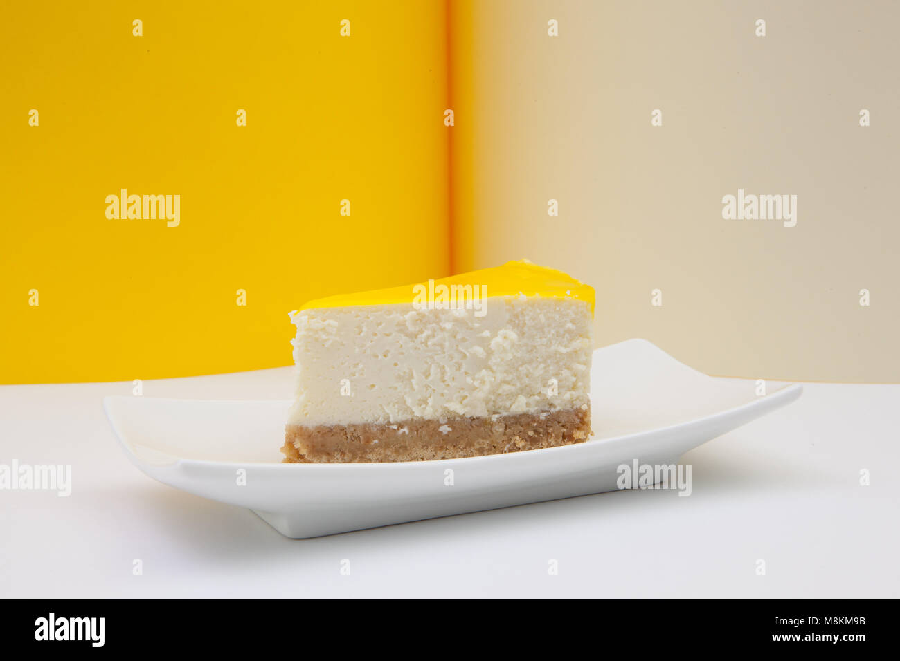 One piece of lemon cheesecake on a white rectangular plate Stock Photo ...