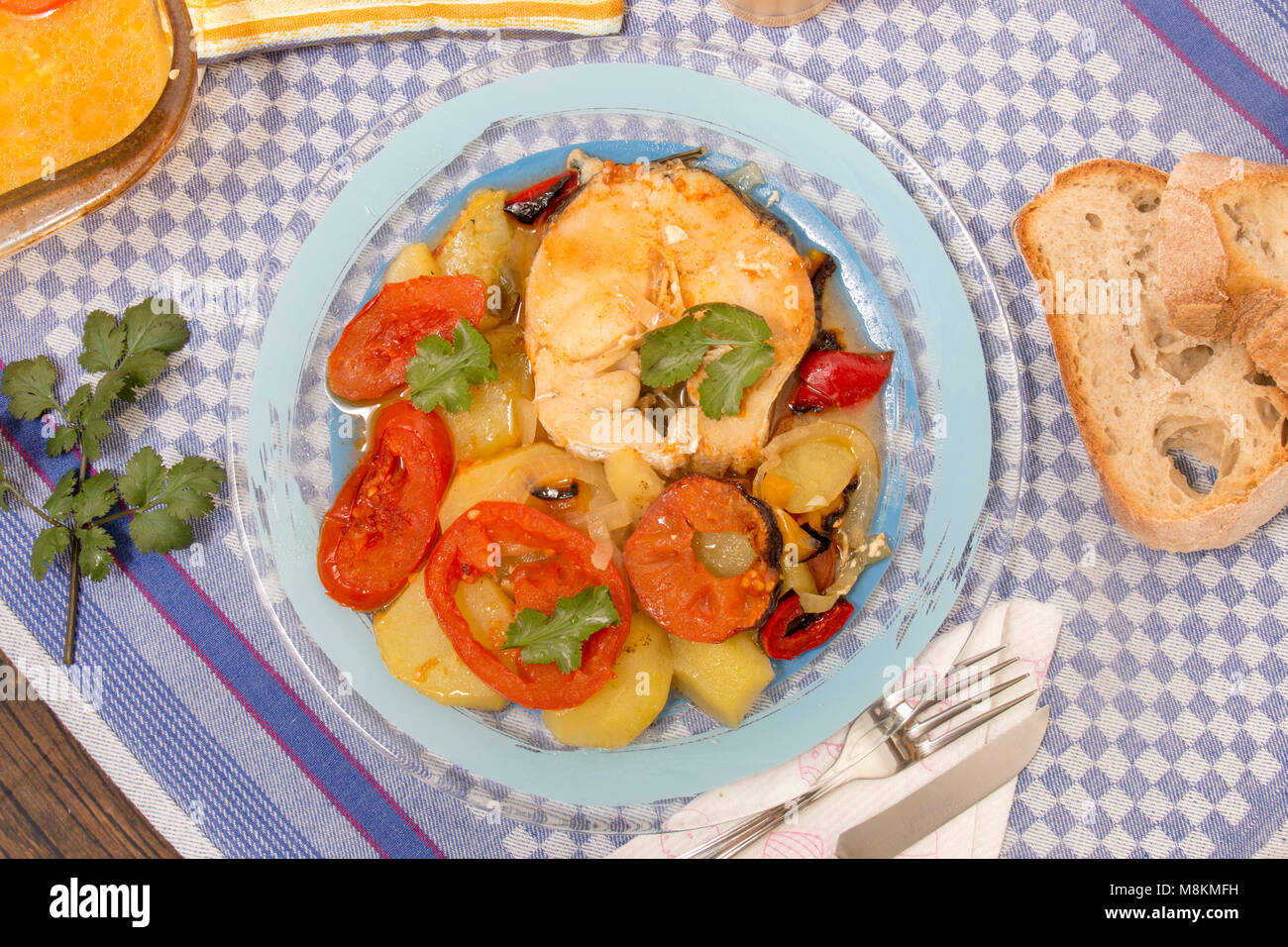 Traditional portuguese meal of fish with potatoes and tomato, made on ...