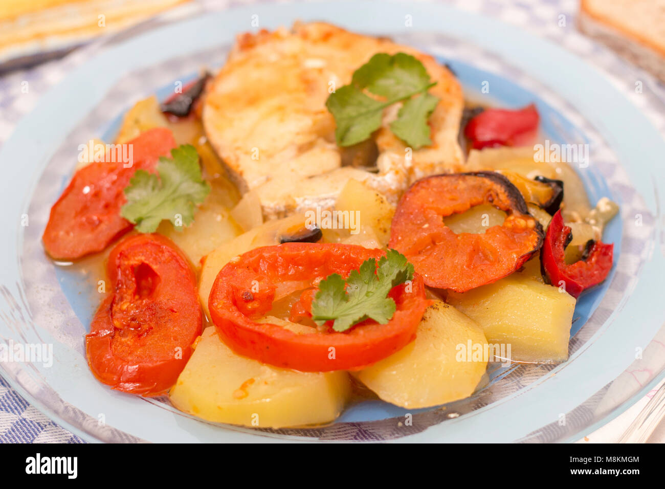Traditional portuguese meal of fish with potatoes and tomato, made on ...