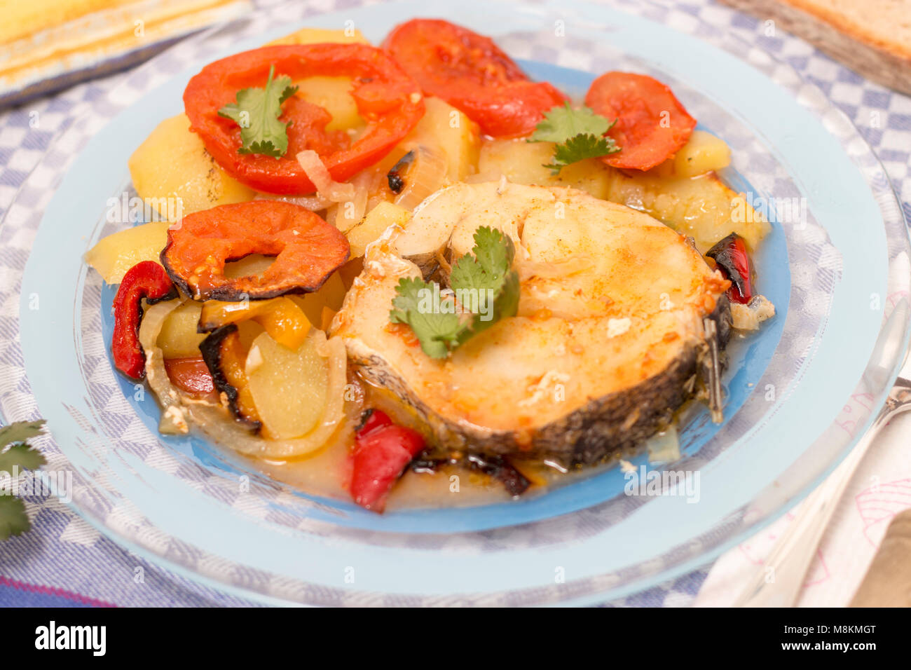 Traditional portuguese meal of fish with potatoes and tomato, made on ...