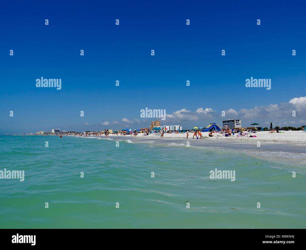 Crowd of people enjoying a sunny day at the beach in March. Treasure ...