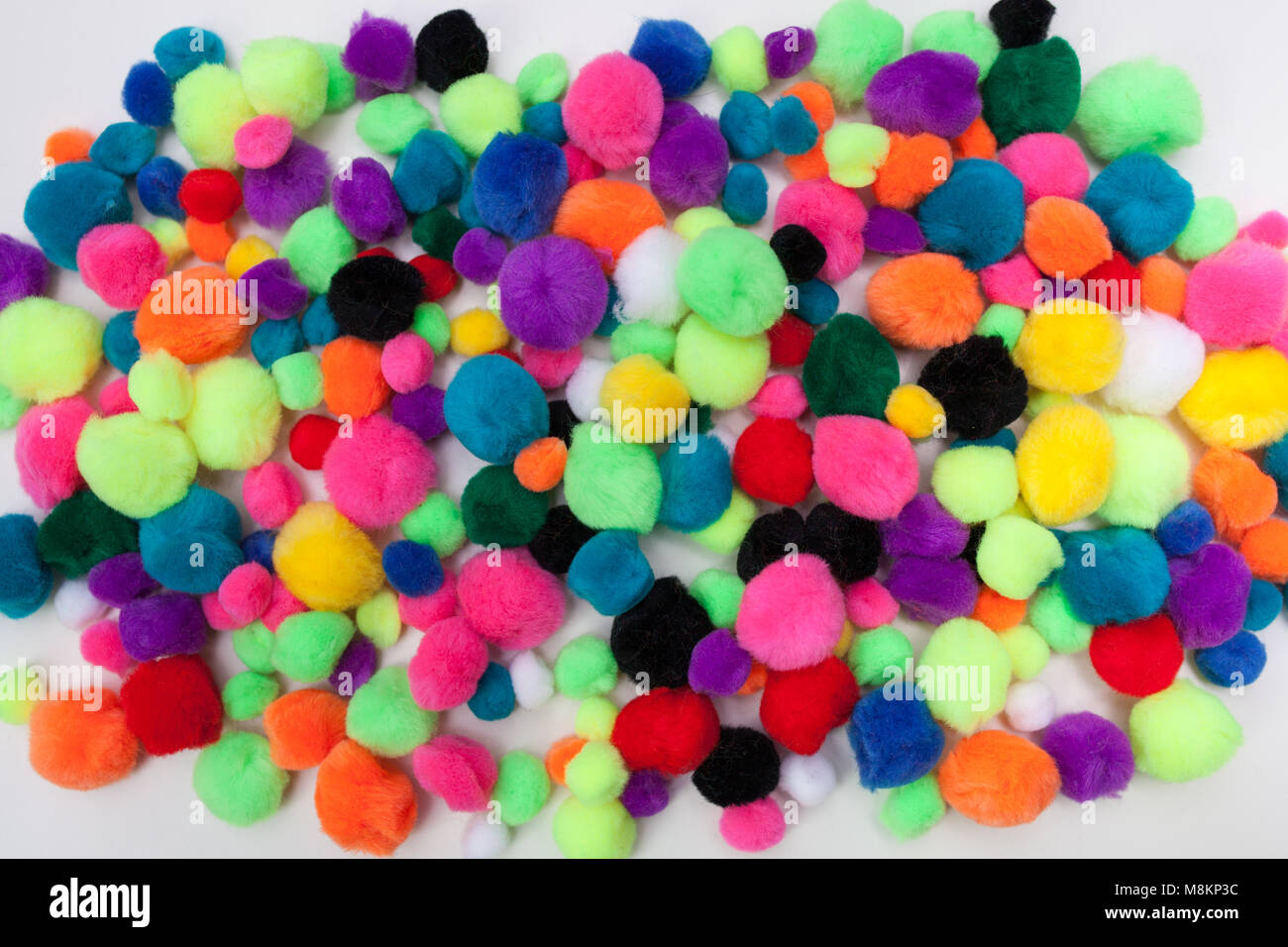 Colorful Pom Poms on a white background Stock Photo - Alamy