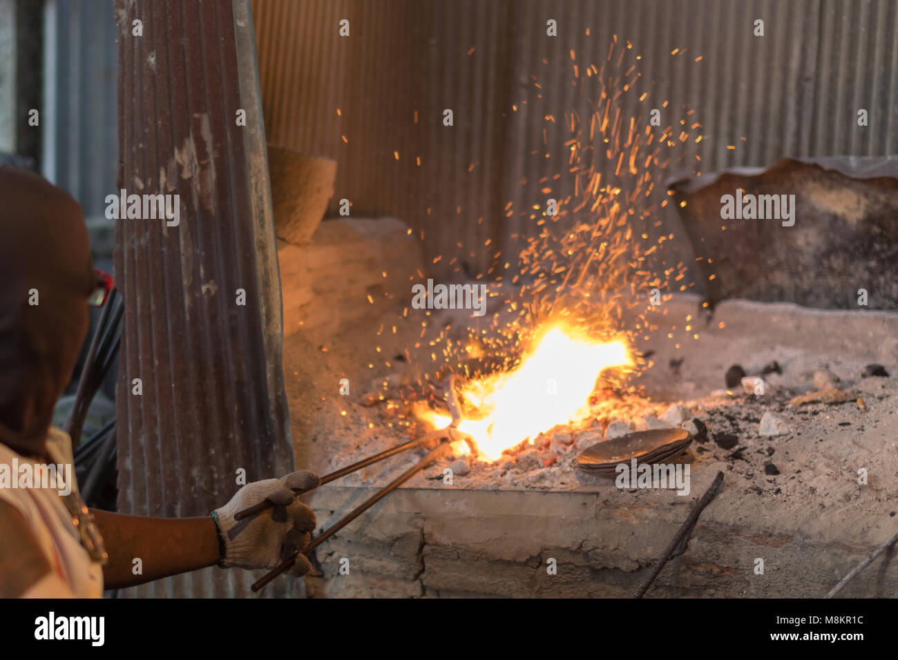 Man working ore to make brass Stock Photo - Alamy