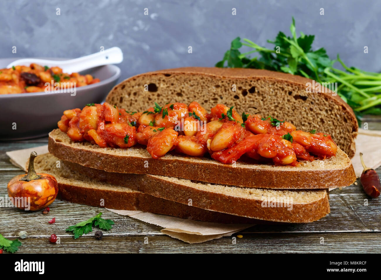 A piece of rye bread with beans. Stewed beans in tomato sauce with ...