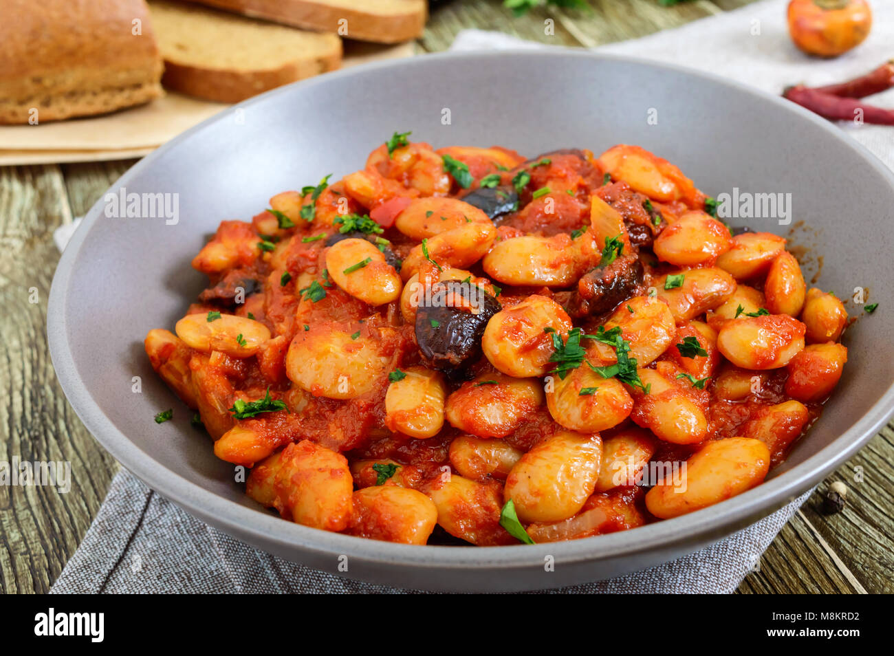 Stewed broad beans in tomato sauce with herbs and spices close-up ...