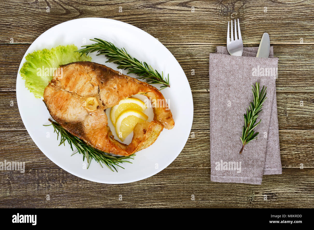 Big roasted carp steak with lemon and rosemary. Top view Stock Photo ...