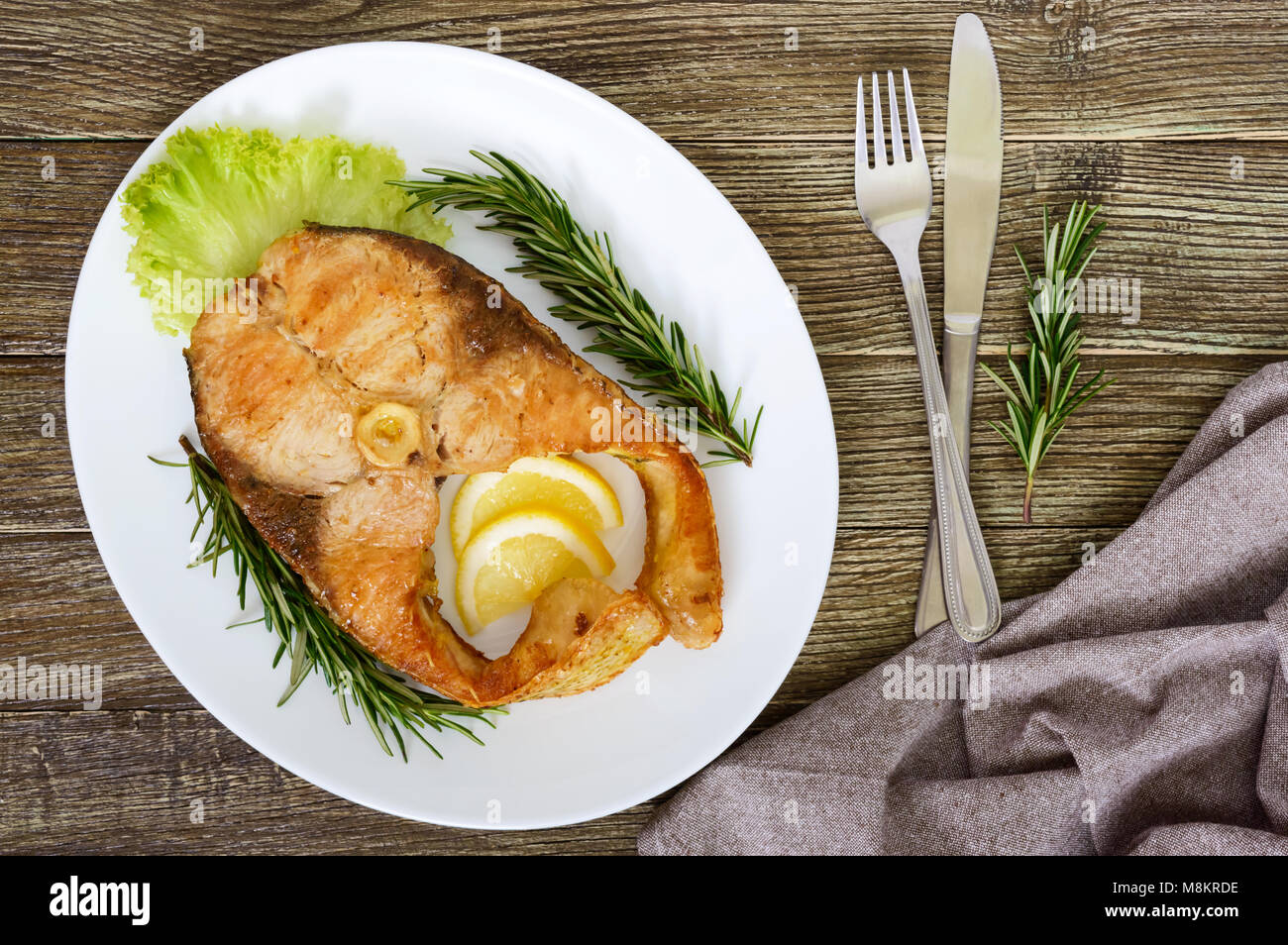 Big roasted carp steak with lemon and rosemary. Top view Stock Photo ...