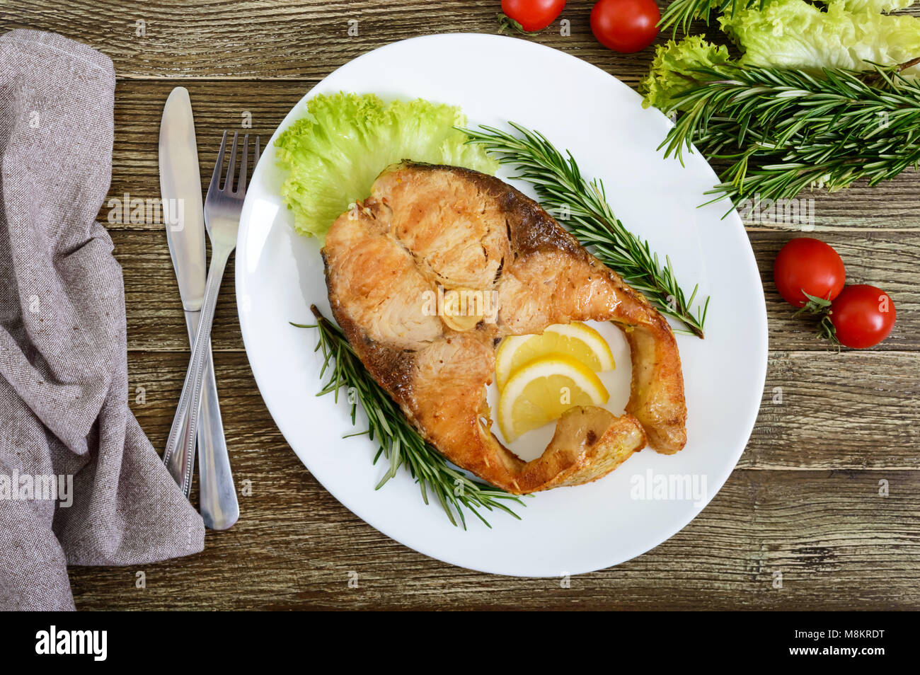 Big roasted carp steak with lemon and rosemary. Top view Stock Photo ...