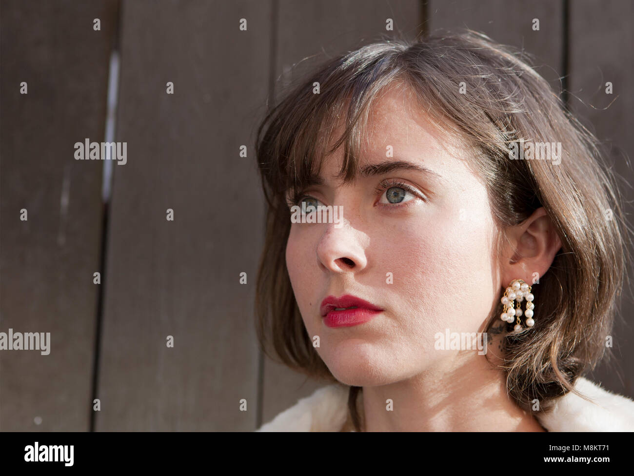 A well dressed woman, standing alone outside, with a concerned look on ...
