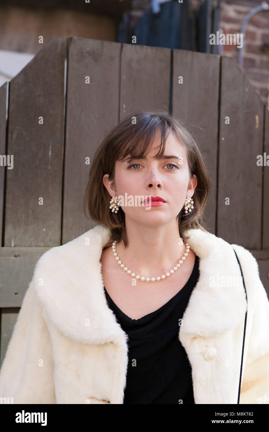 A well dressed woman, standing alone outside, with a concerned look on ...