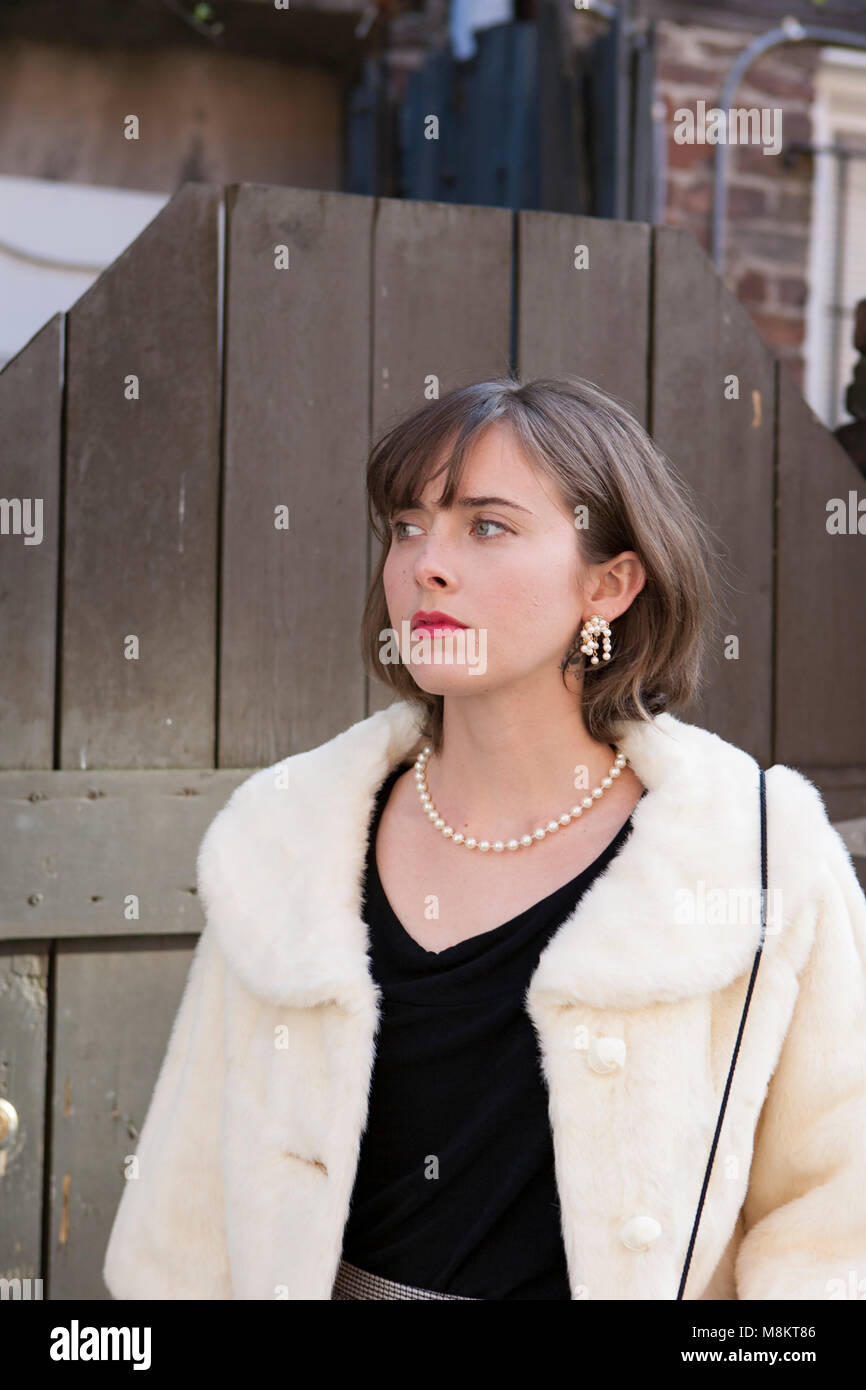 A well dressed woman, standing alone outside, with a concerned look on ...