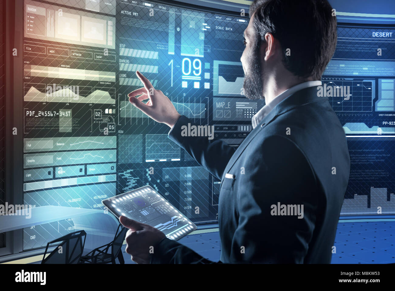 Bearded programmer pointing to his computer while holding a transparent ...