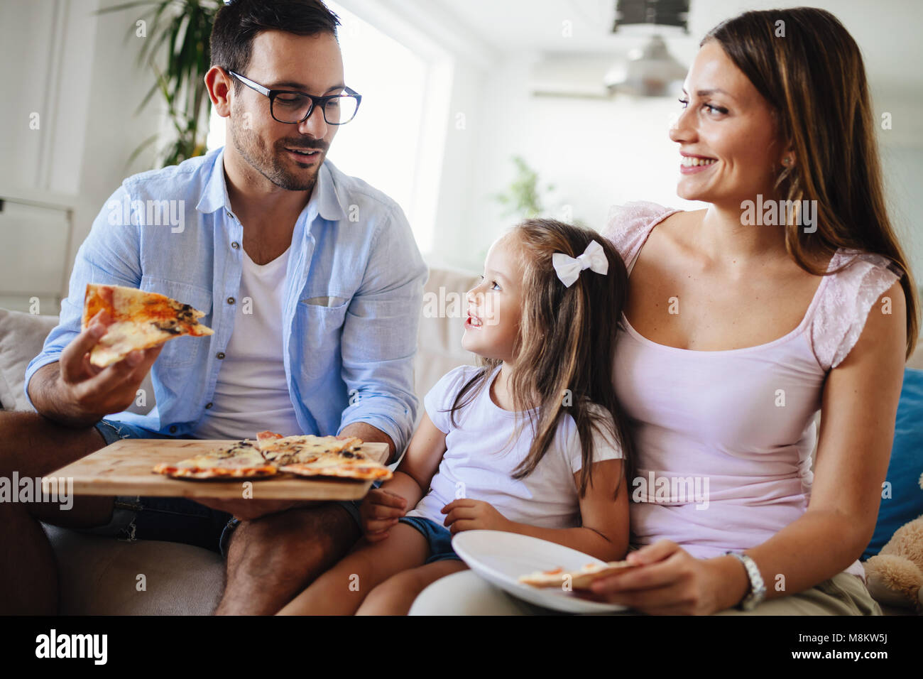 Happy family sharing pizza together at home Stock Photo - Alamy