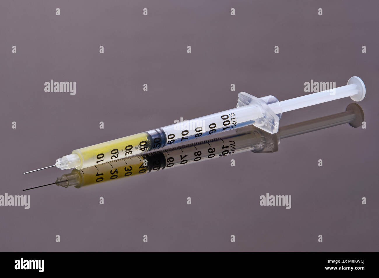 Full syringe and needle on grey background Stock Photo - Alamy