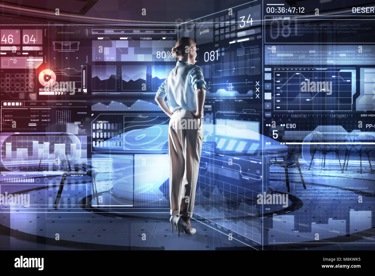 Elegant programmer standing with her hands on the hips and thinking ...