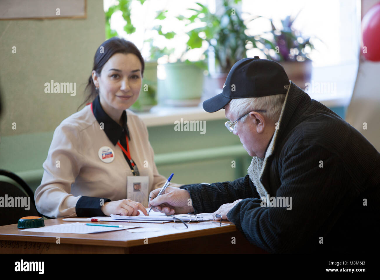 MOSCOW, RUSSIA - MARCH 18, 2018: The voter receives a ballot paper at ...