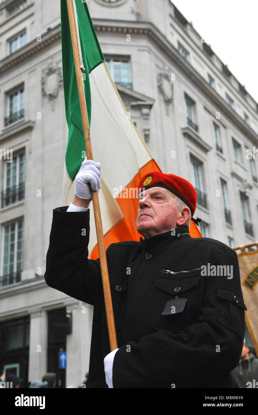 London, UK. 18th March, 2018. A flag bearer carrying the Irish ...