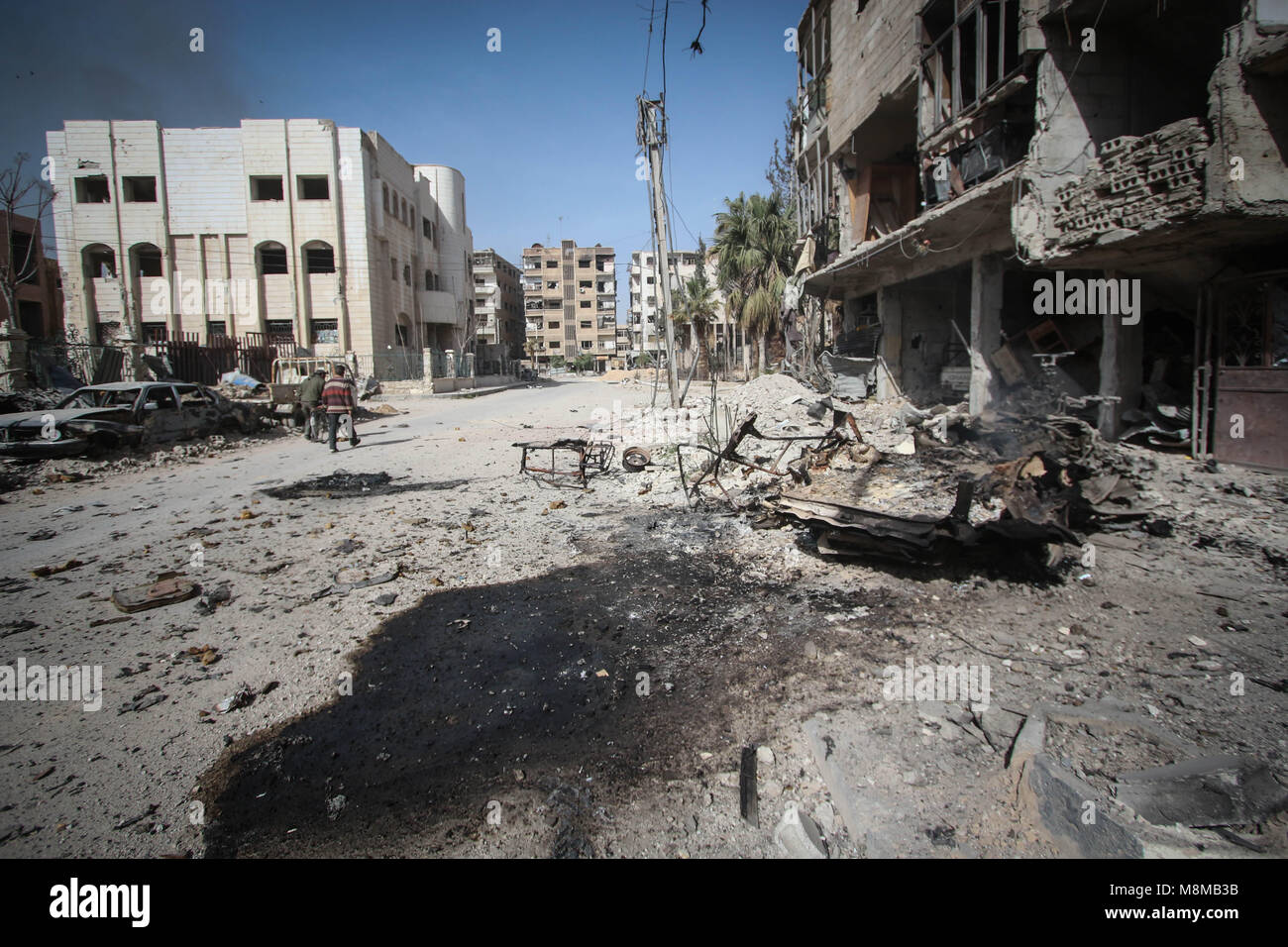 Douma, Syria. 19th Mar, 2018. A man seen walking through the rubble the ...