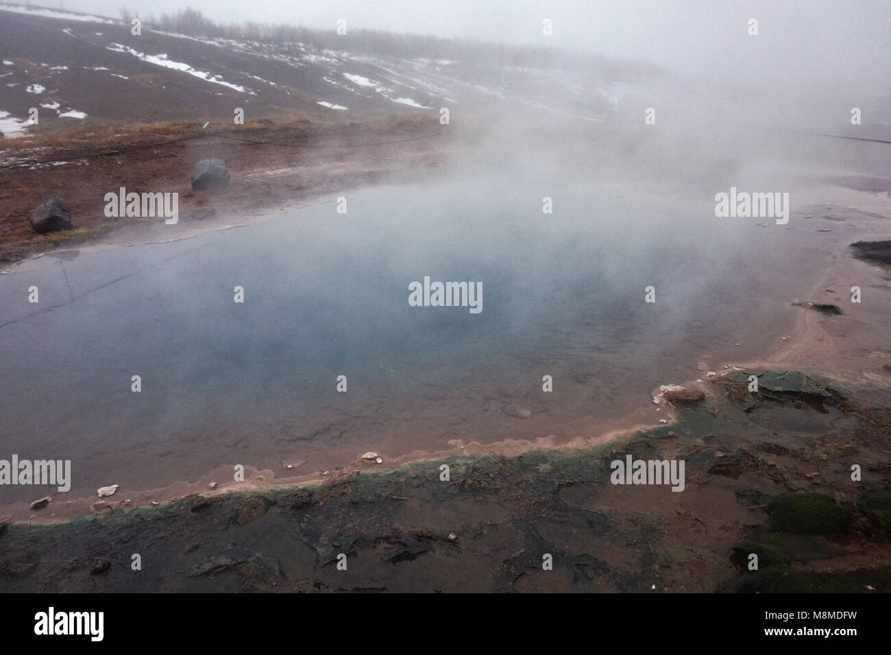 Steaming hot pools coloured by minerals at Haukadalur geothermal area ...