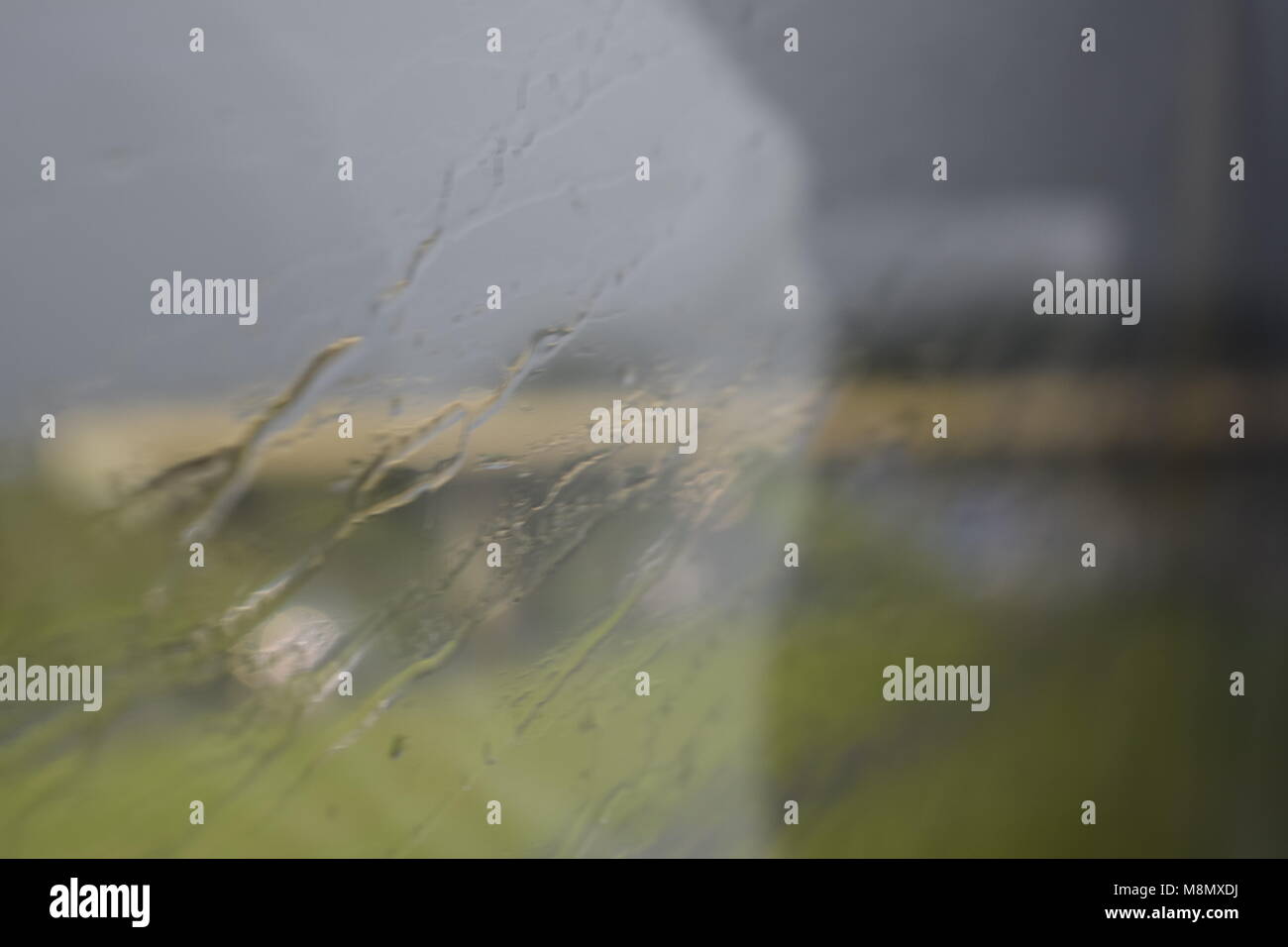 Rainy day bus window with water dripping from the glass Stock Photo - Alamy
