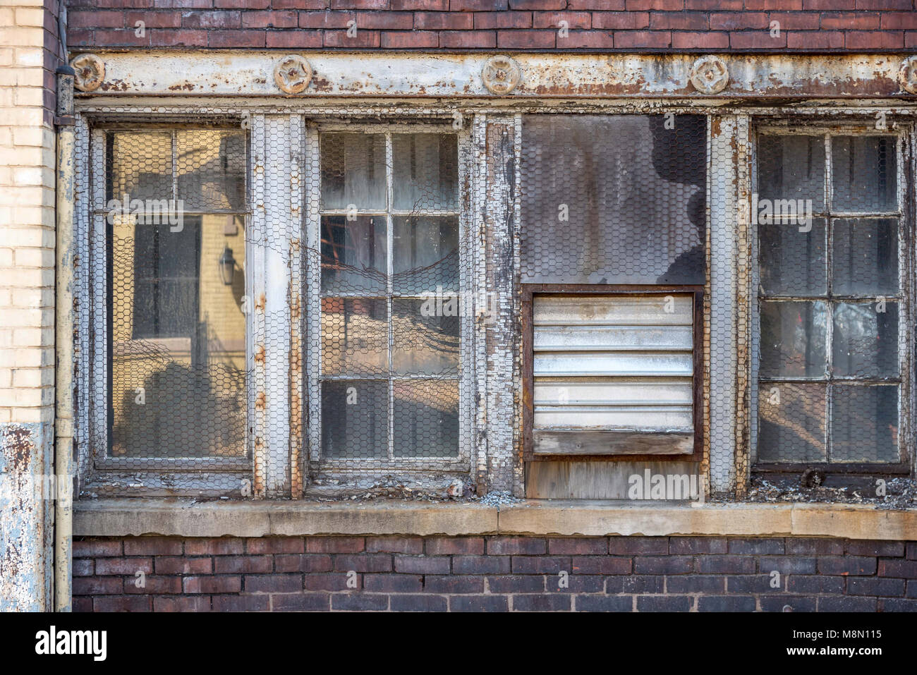 chicken wire covering old abandoned factory building windows in inner ...