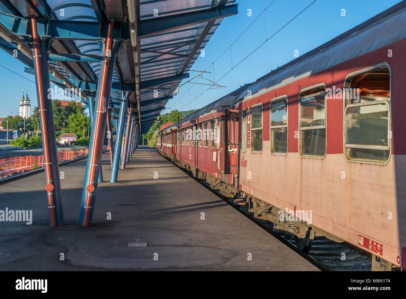 Train station with red train waiting to departure Stock Photo - Alamy