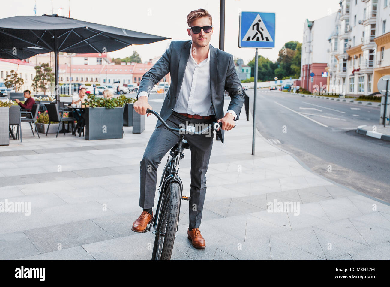Businessman riding bicycle to work on urban street in morning Stock ...