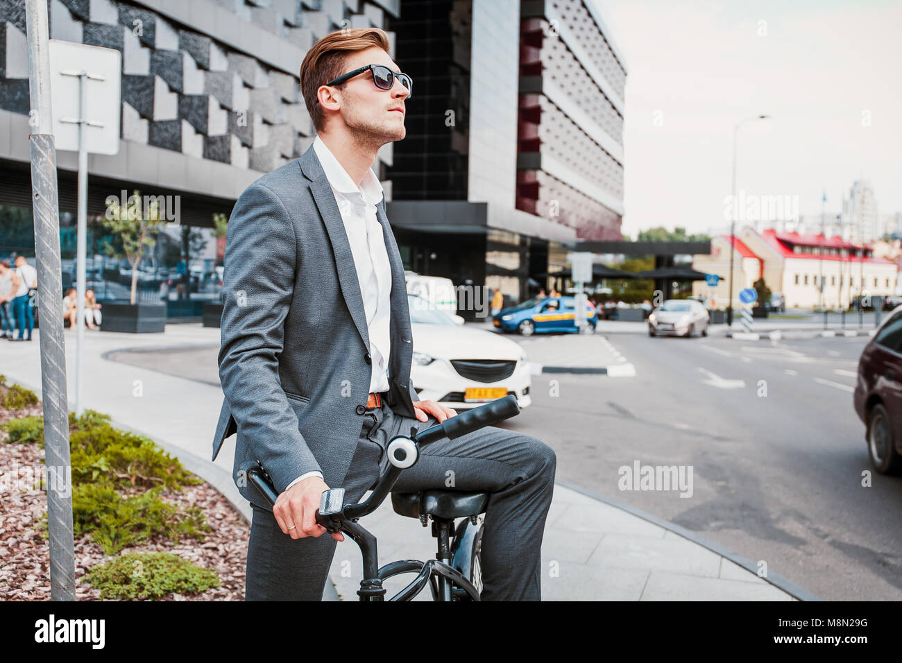 Businessman riding bicycle to work on urban street in morning Stock ...
