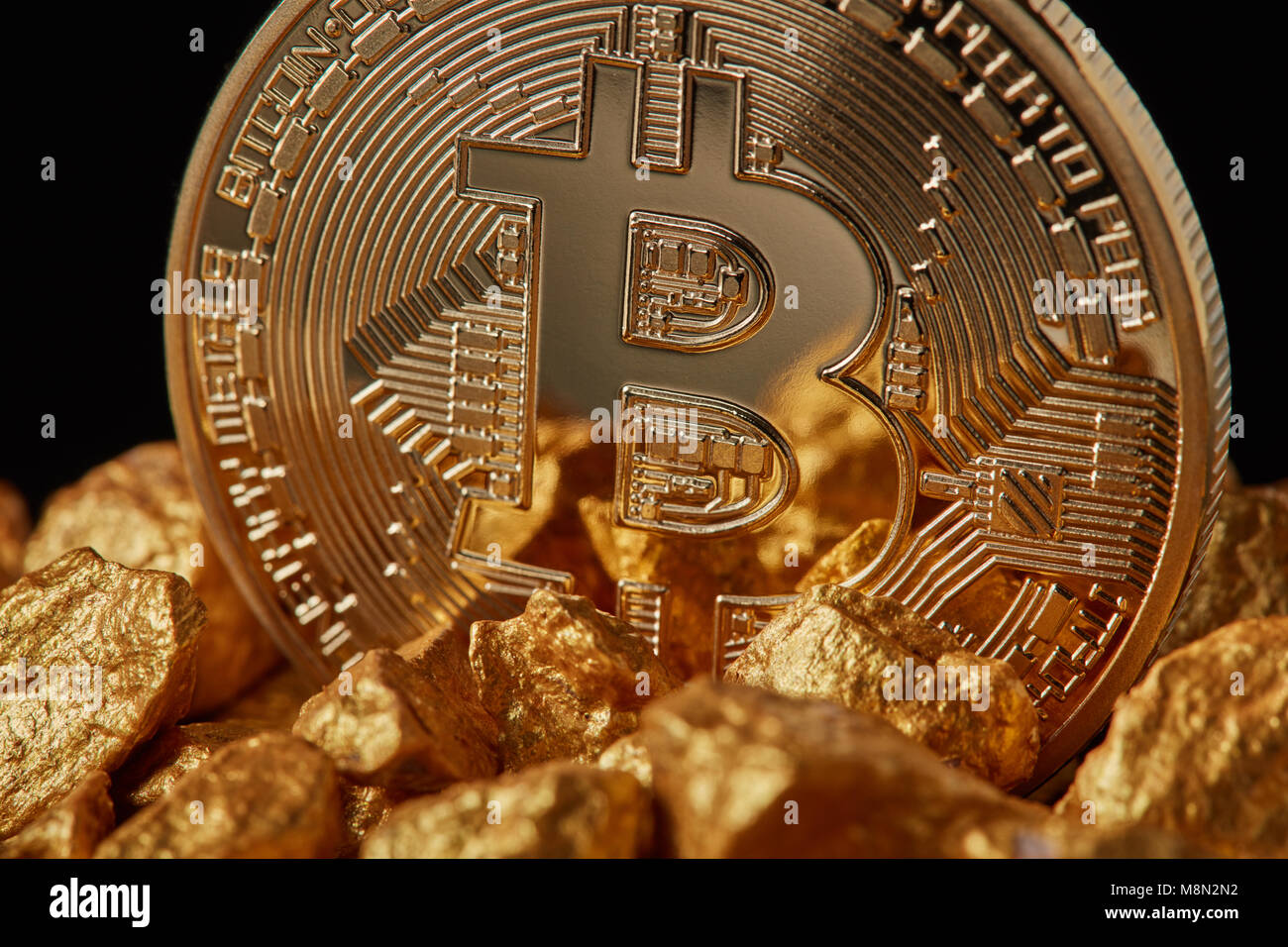 Closeup of gold nugget and Gold Bitcoin Coin on black background Stock ...